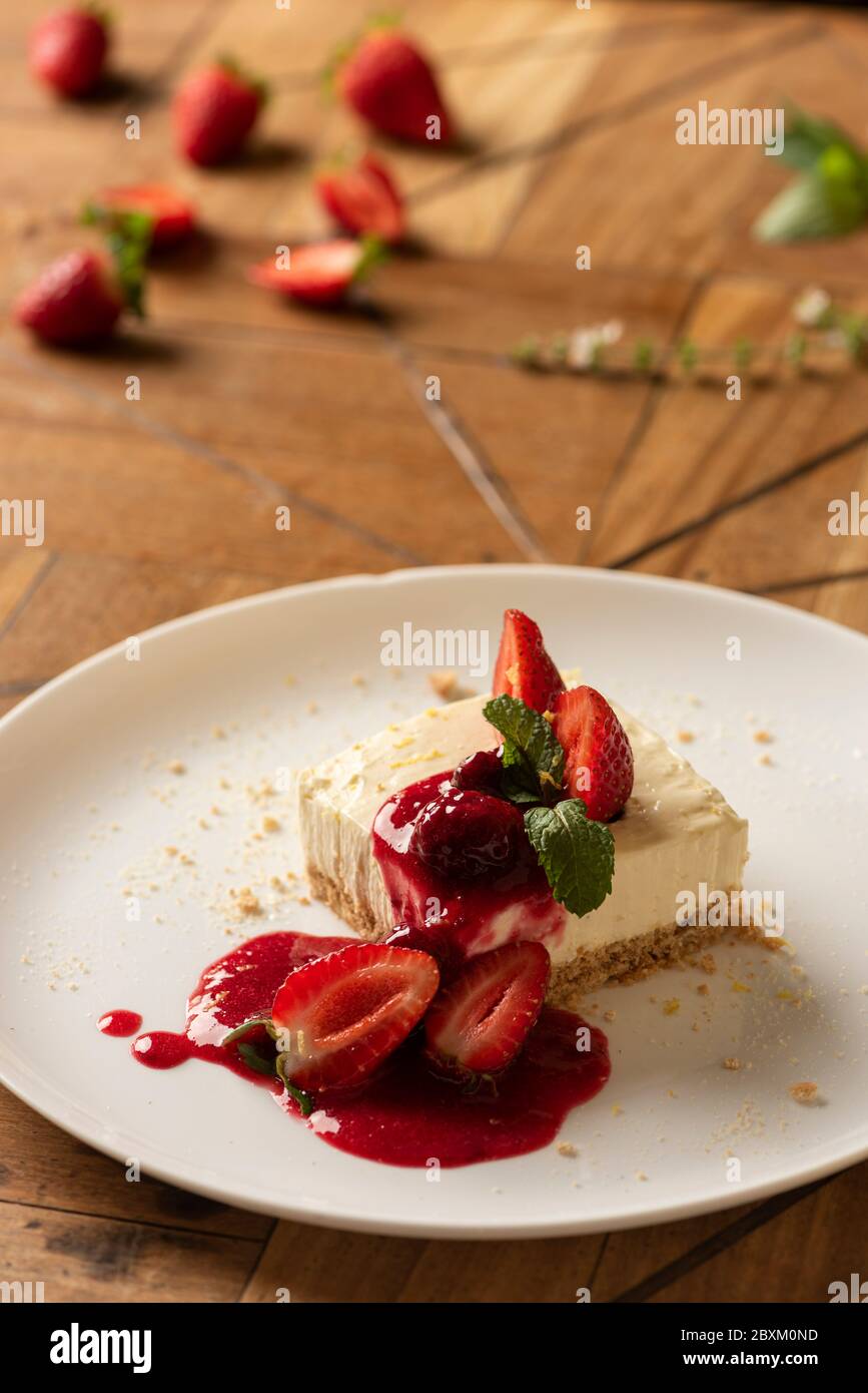 cheesecake with strawberry on white plate and a blurred background with ...