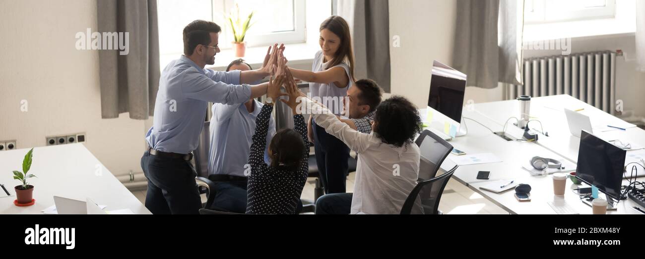 Group of multiethnic employees celebrating success giving high five ...