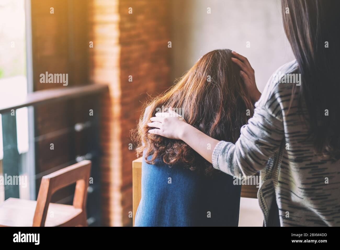 A woman comforting and giving encouragement to her sad friend Stock ...