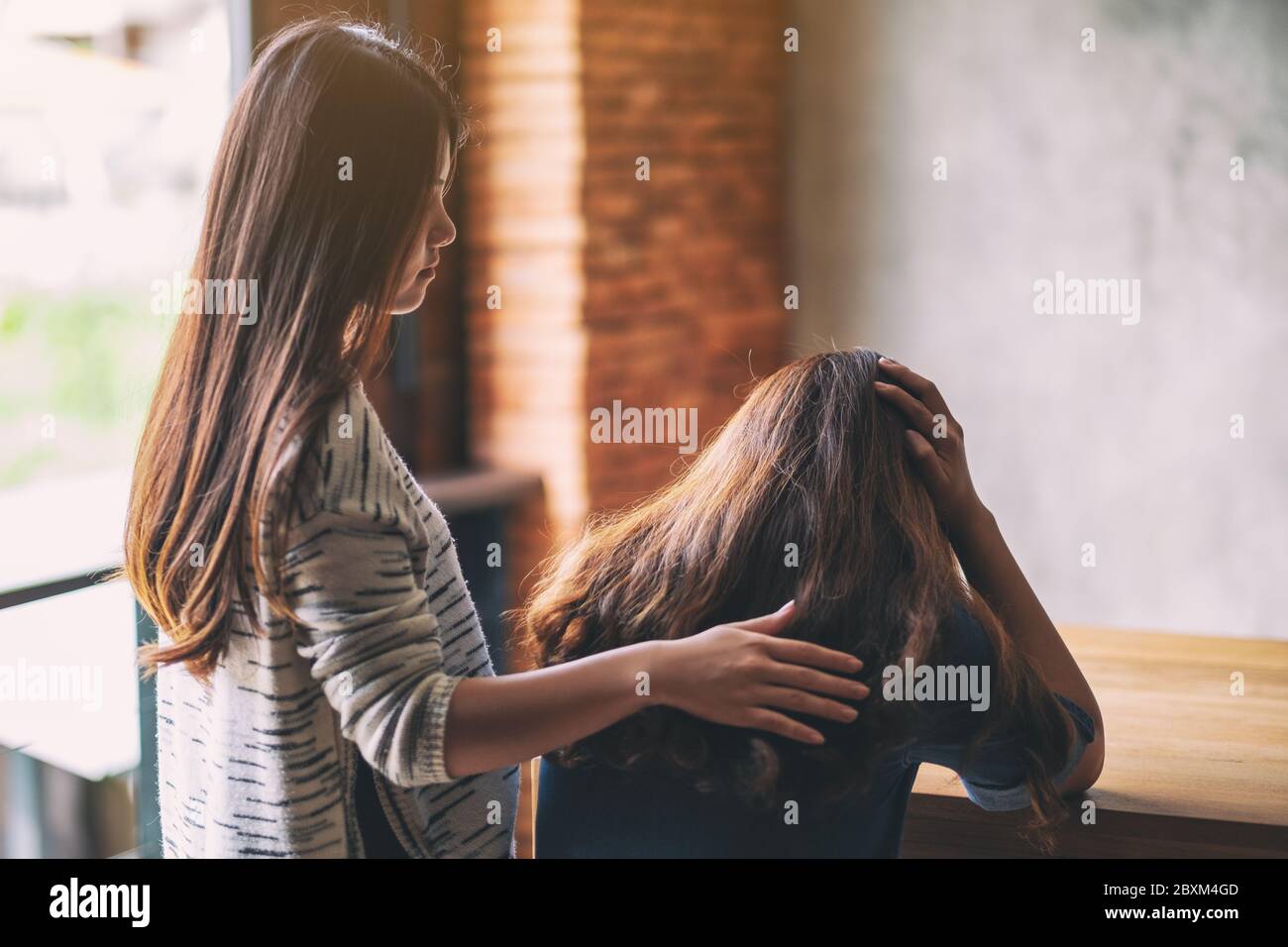 Person comforting crying asian woman hi-res stock photography and ...
