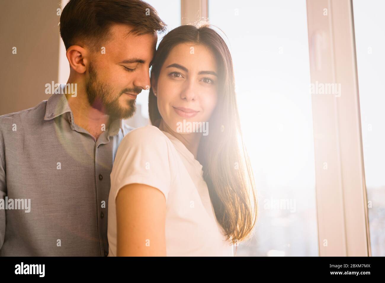 Portrait loving couples enjoying each other company with window in ...