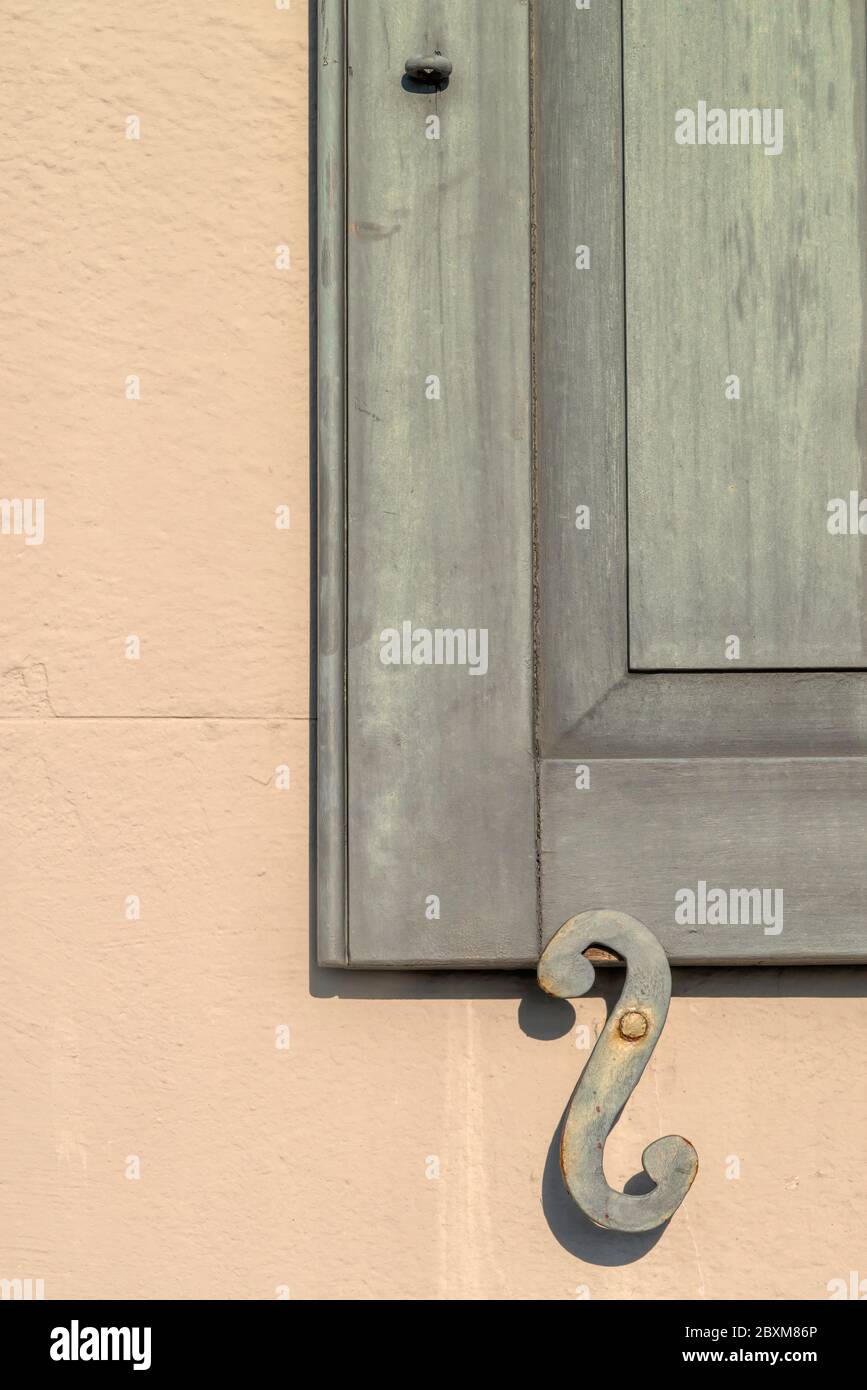 Close up of an antique shutter latch holding a green wooden shutter ... Close up of an antique shutter latch holding a green wooden shutter ...