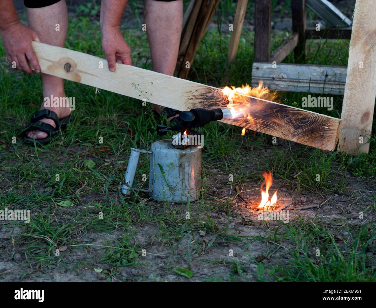 Hand of a man burning a board with a blowtorch Stock Photo - Alamy
