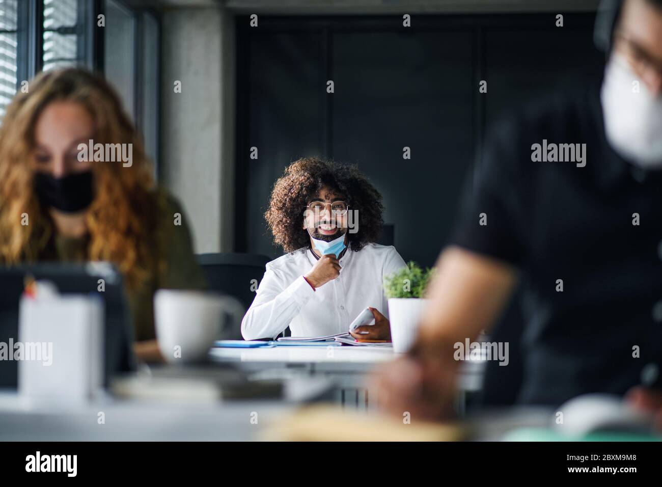 Young people with face masks back at work or school in office after ...