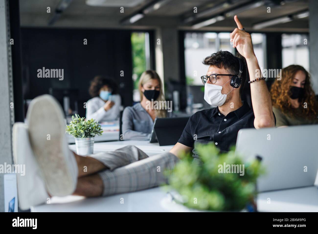 Young people with face masks back at work or school in office after ...