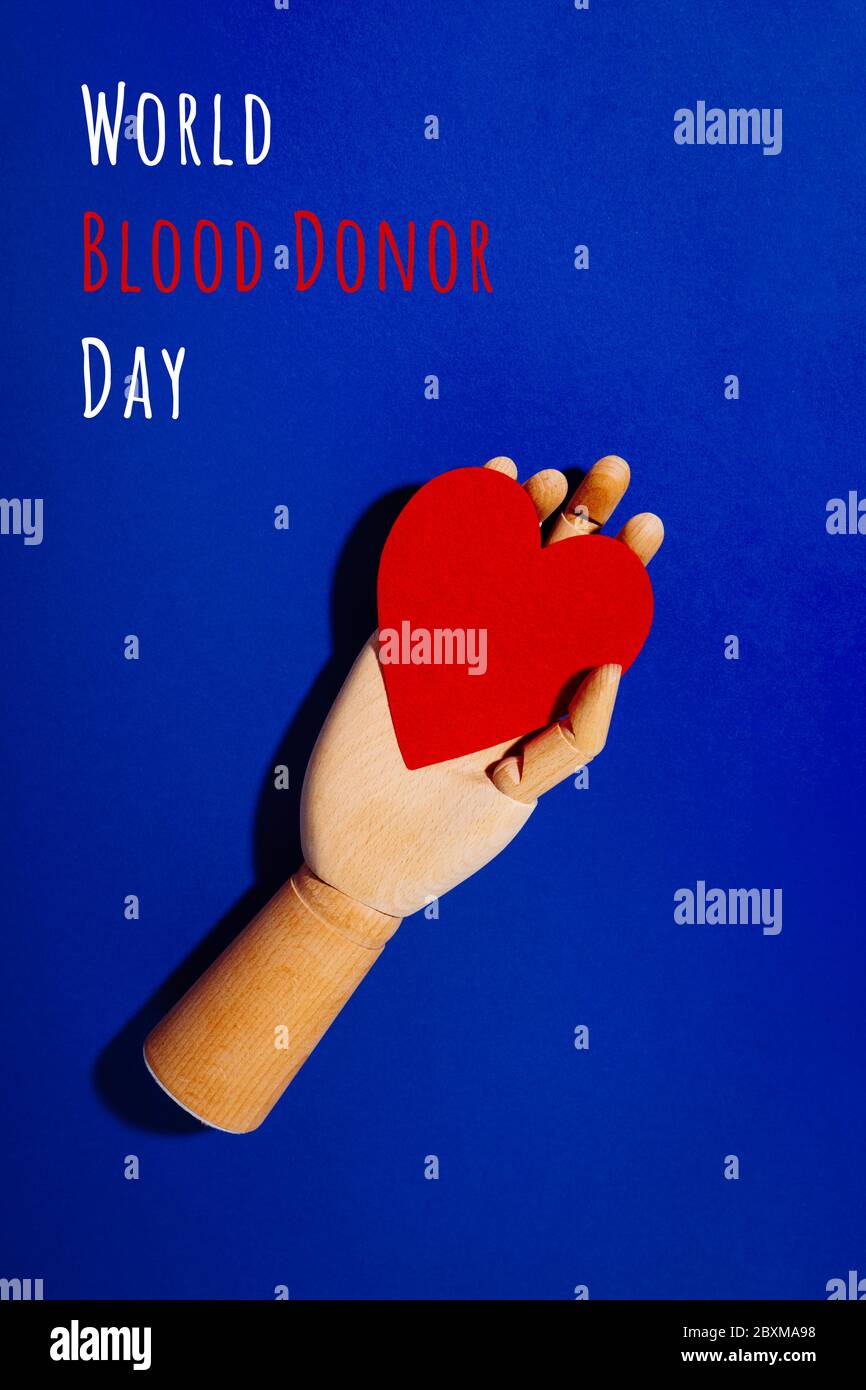 Wooden hand with big red heart in a giving gesture. World Blood Donor ...