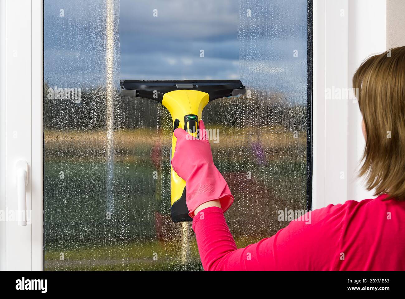 attractive wife washing a window. Gloved hand cleaning window rag and ...