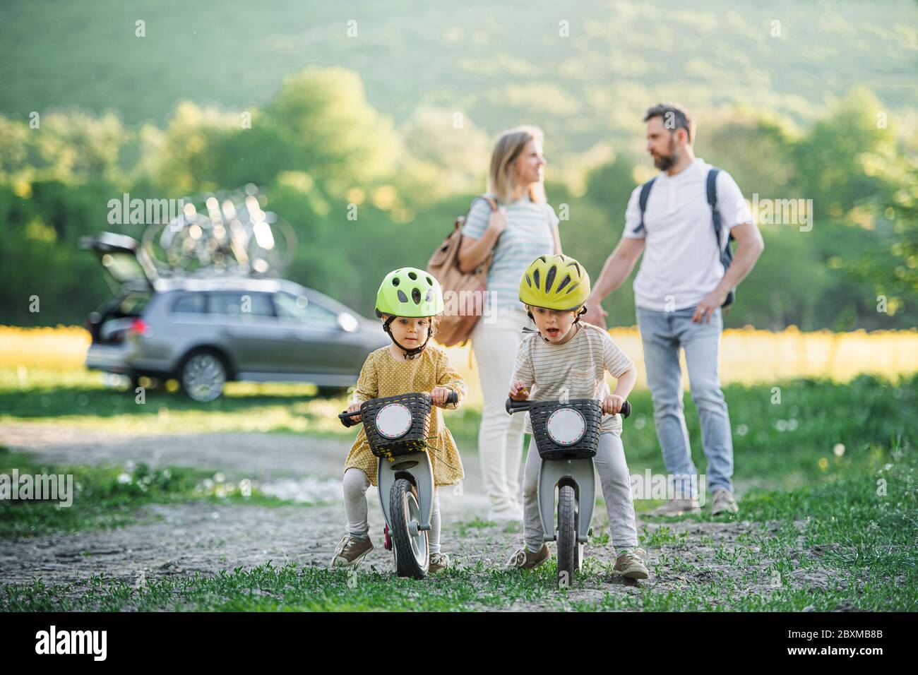 Family with two small children going on cycling trip in countryside ...