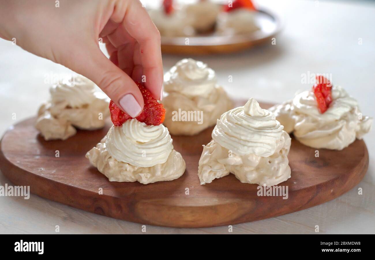 decorating the meringue with strawberries Stock Photo - Alamy