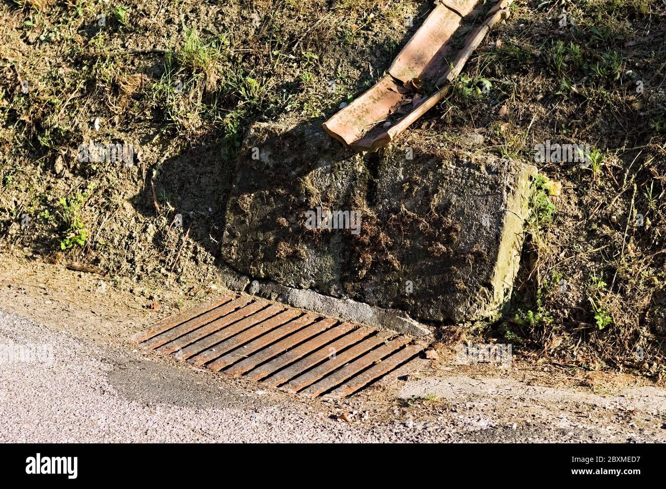 Channel for water collection and a rusted drain grid on the road ...