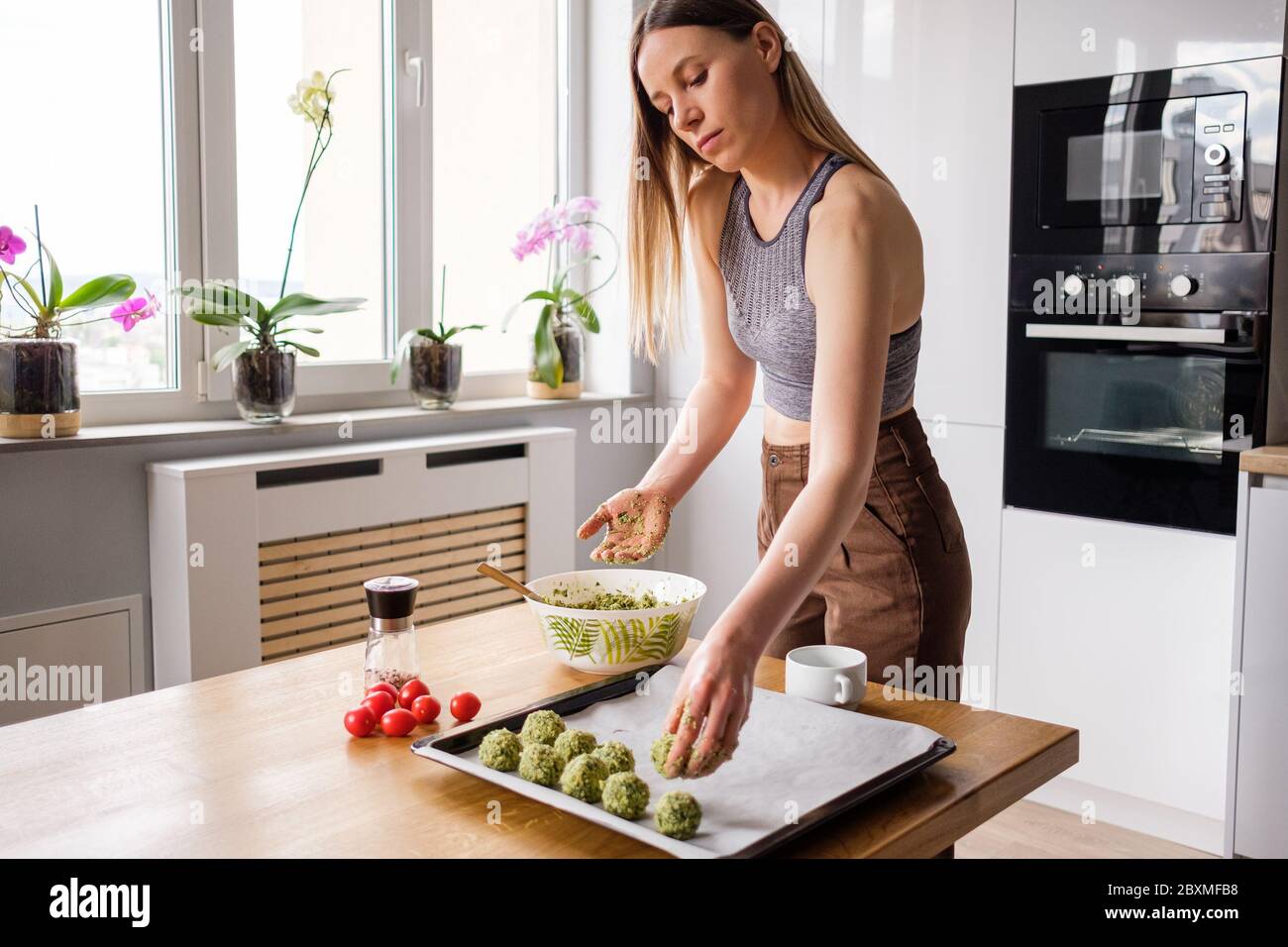 Lovely woman with beautiful hands cooking falafel in a modern kitchen ...