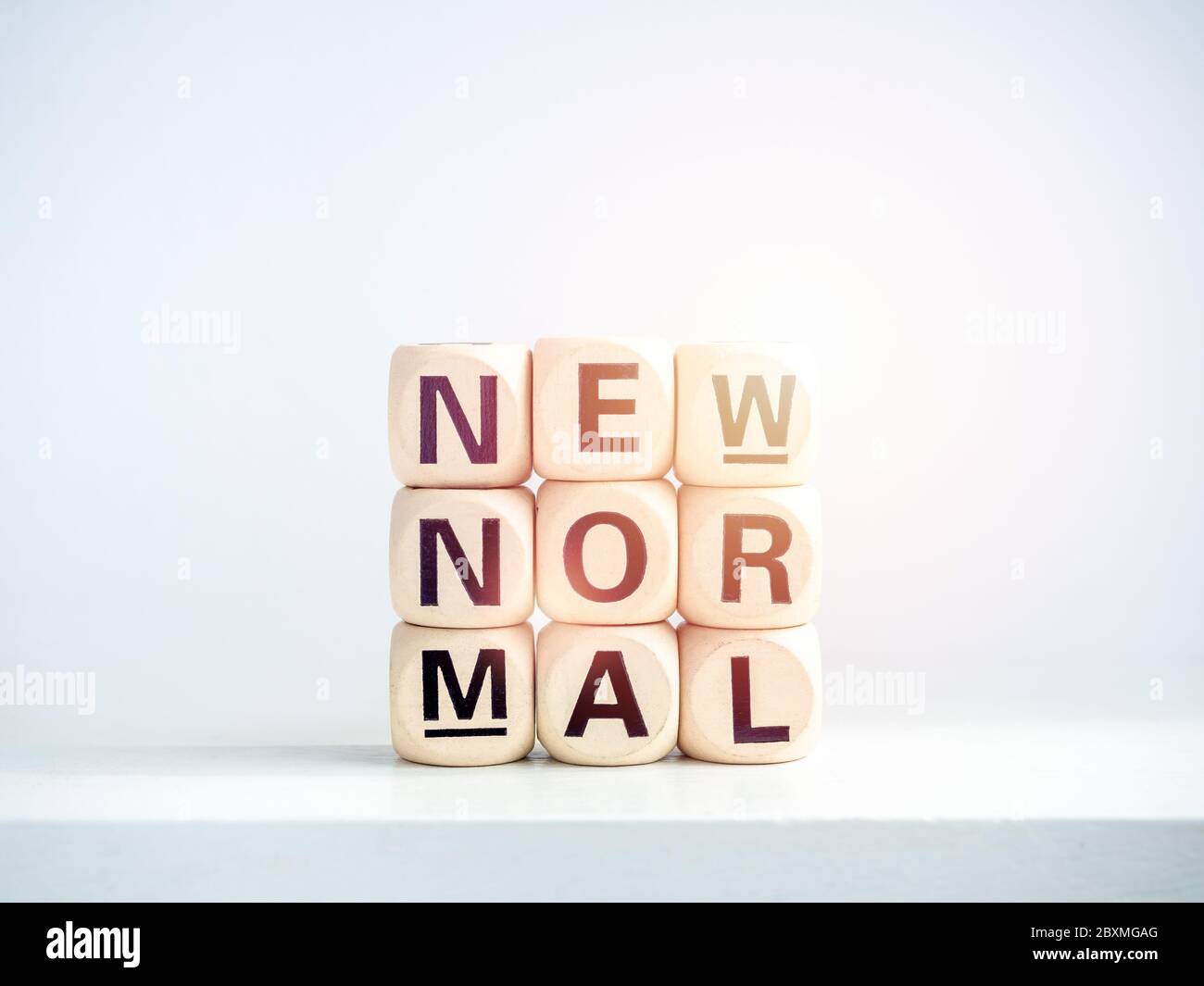 Close-up New Normal, words on wooden alphabet cube on shelf on white ...