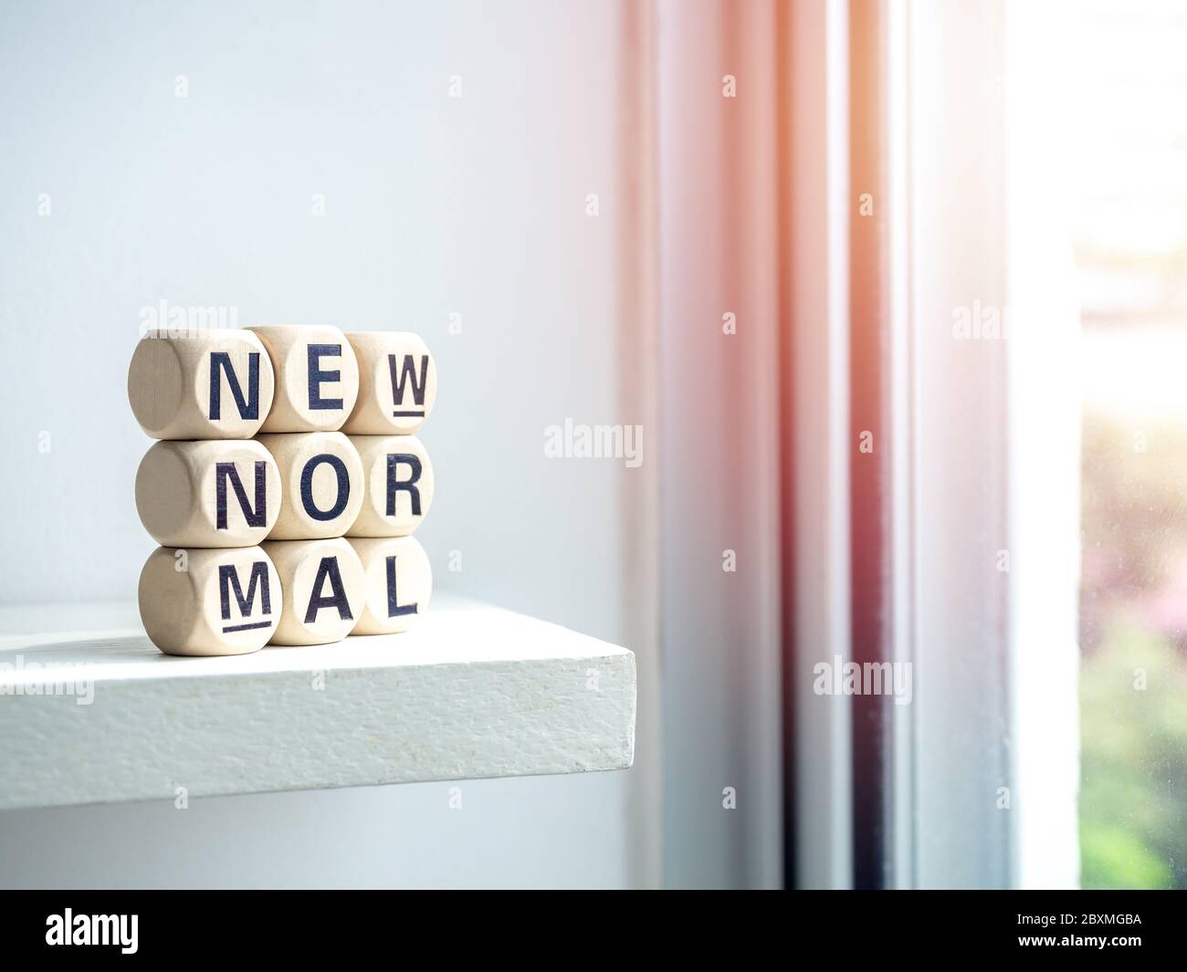 Close-up New Normal, words on wooden alphabet cube on shelf near window ...
