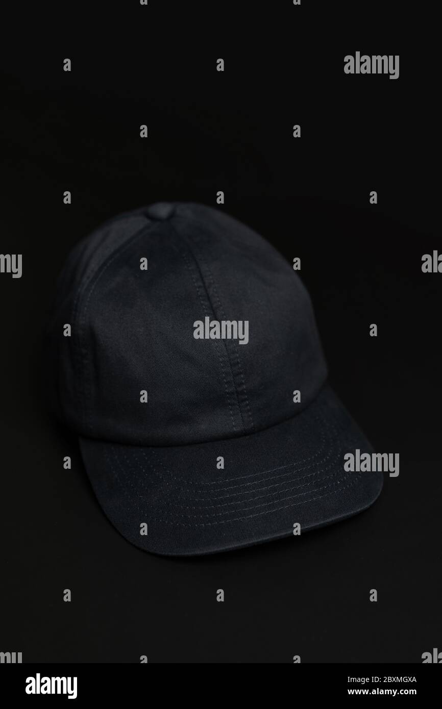 Black cloth cap / hat on the dark black background Stock Photo - Alamy