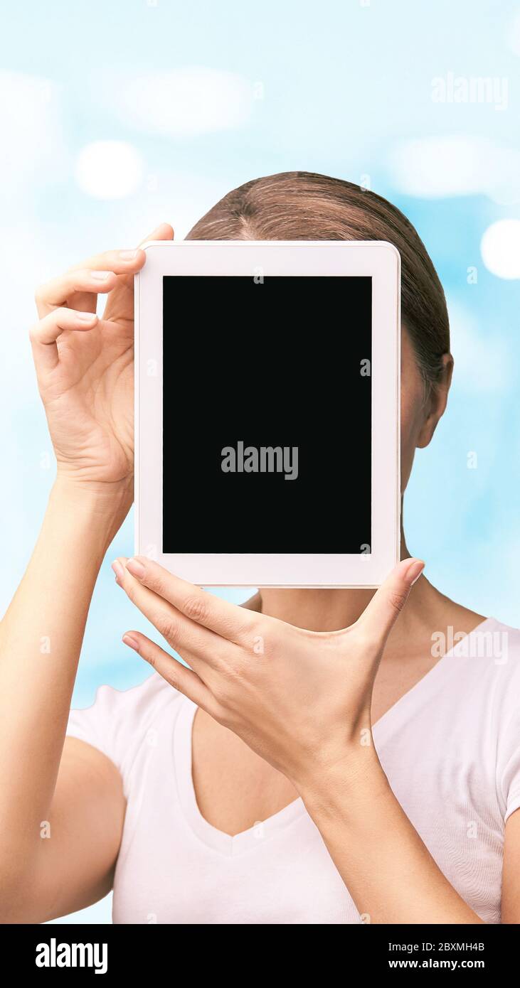 Girl holding computer pad. Mock up at tablet black screen. Face near ...