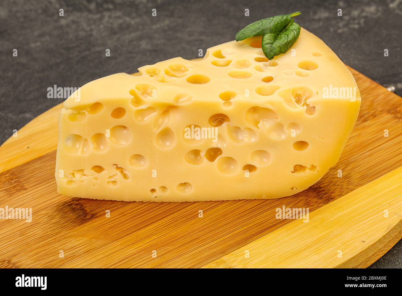 Maasdam cheese - dairy yellow triangle with holes Stock Photo - Alamy
