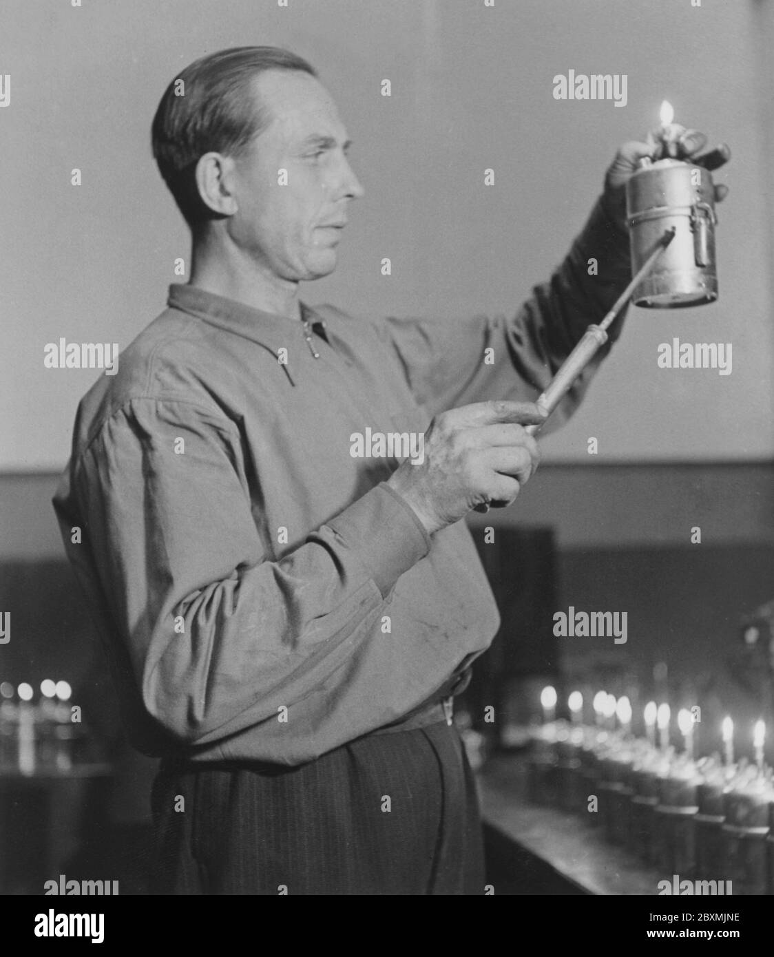 In the 1940s. A man at at a carbide lamp factory. A lamp that produce ...
