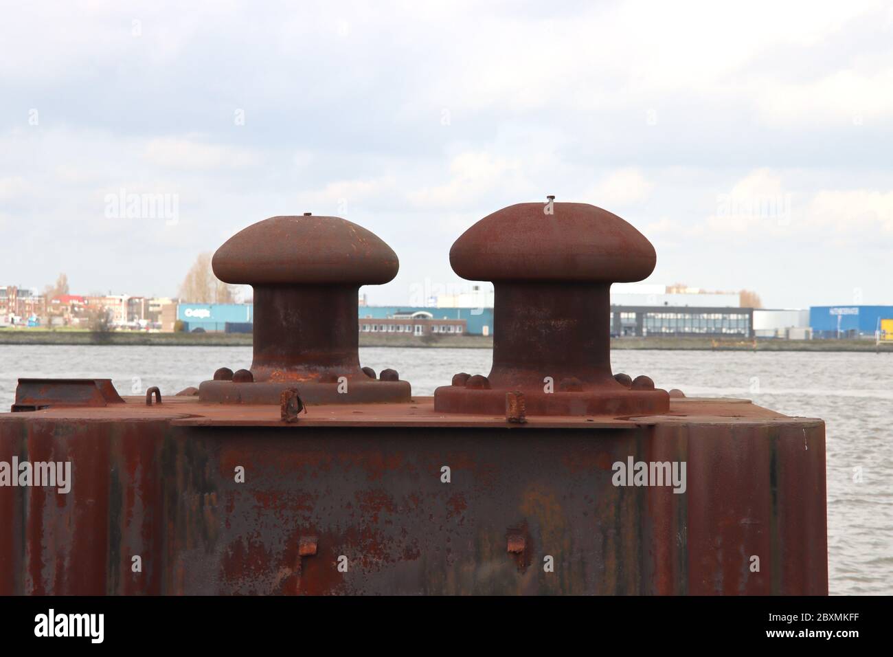 Rust-colored bollard for mooring ships in the port of Rotterdam in the ...