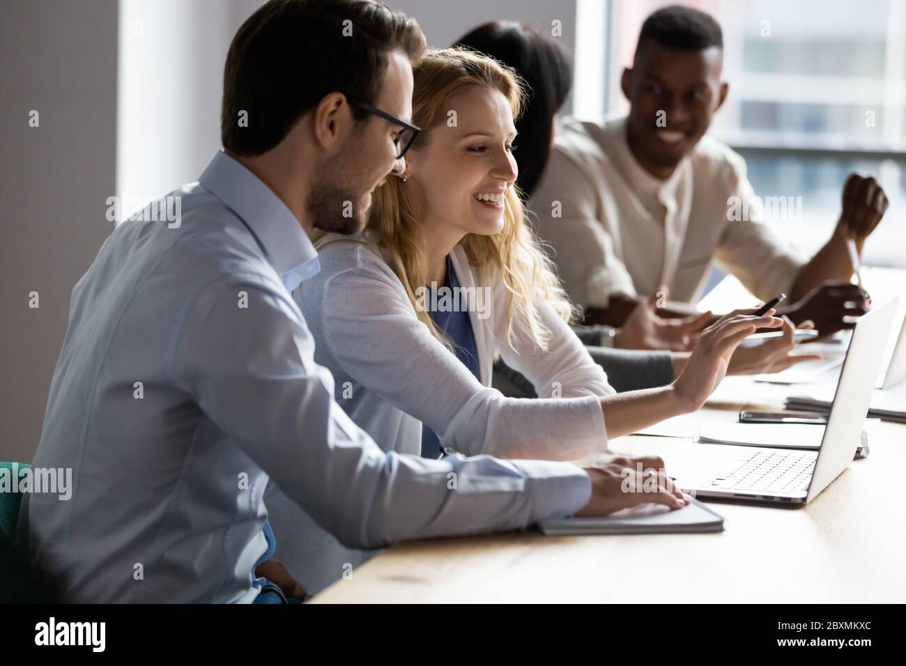 Colleagues working on common project prepare presentation using laptop ...