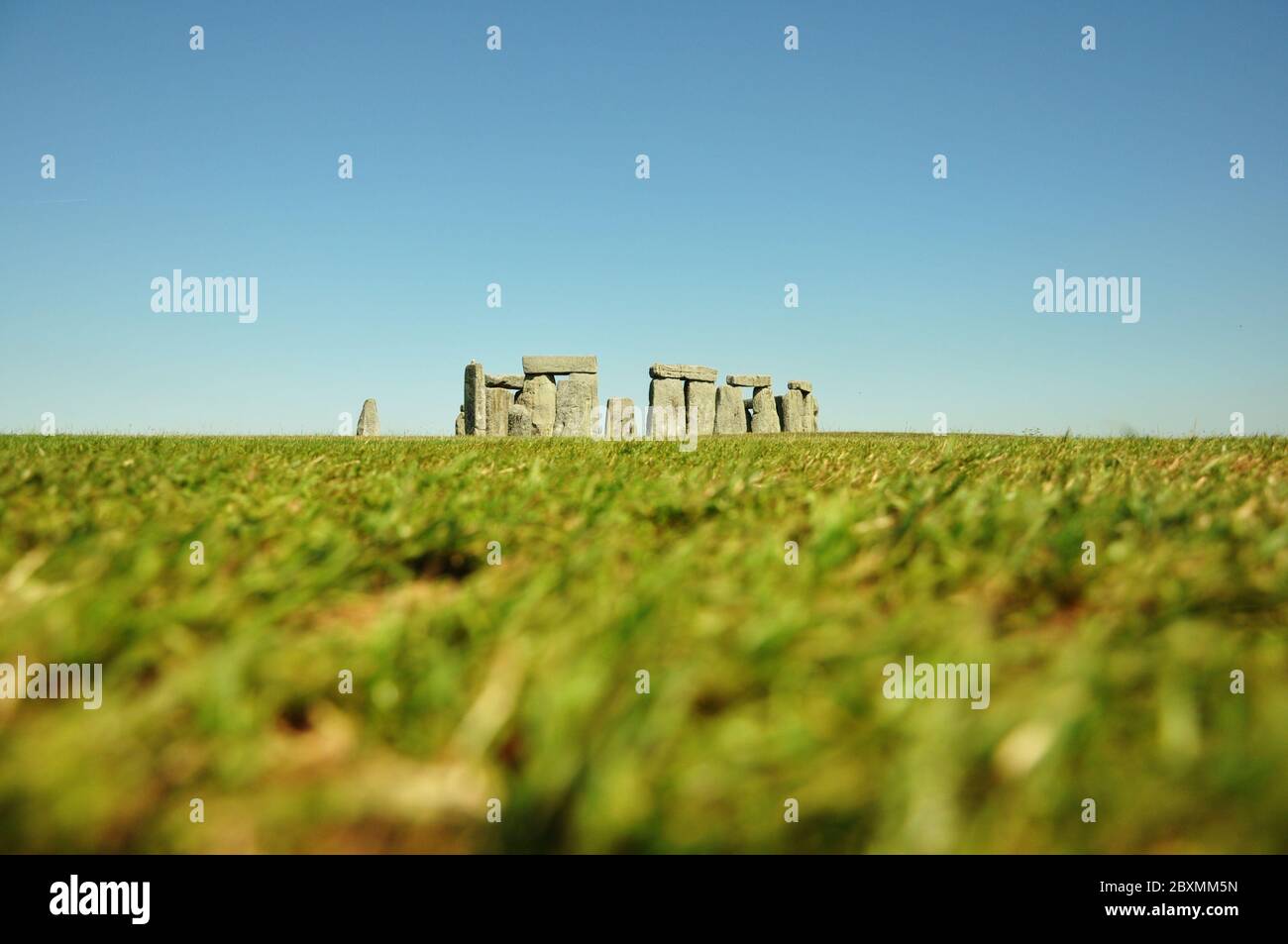 Grassy field and blue clear sky with Stonehenge background Stock Photo ...