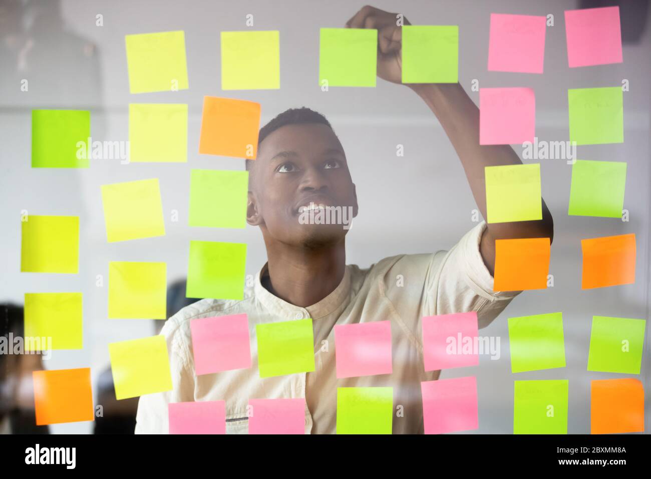 African worker writing on colorful sticky notes produces fresh ideas ...