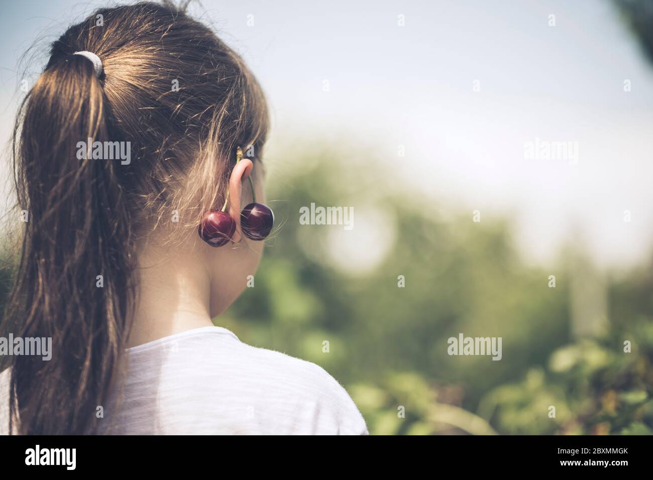 Beautiful little girl got a fresh cherry on her ear. Adorable little ...