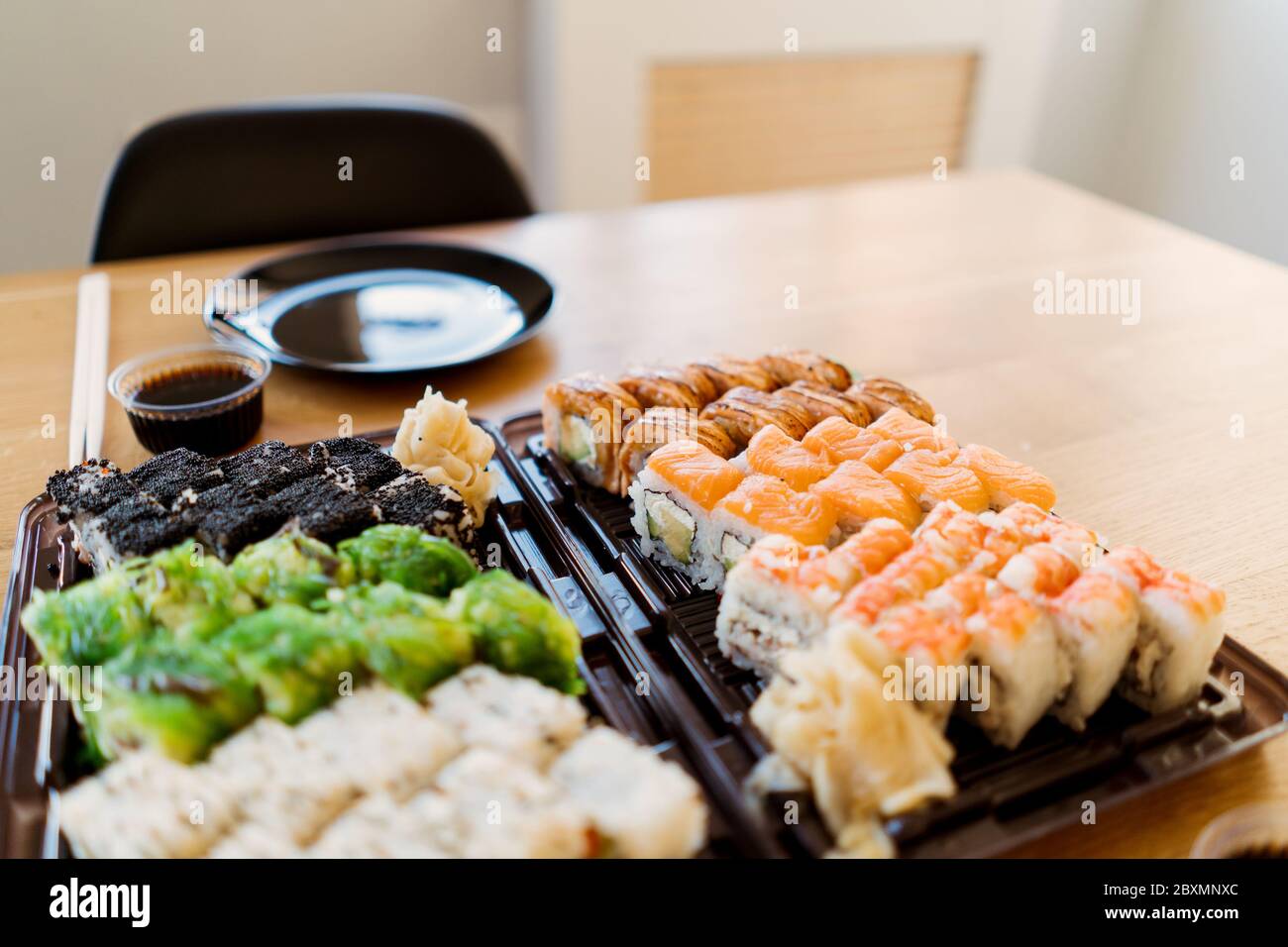 Close up of mix of sushi rolls on a table at home. Waiting friends to ...