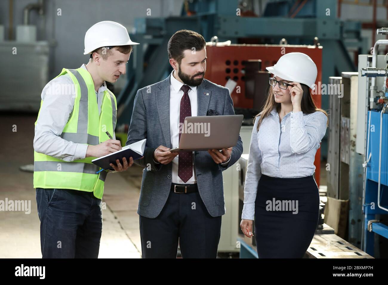Portrait of a solid businessman with his secretary and factory engineer ...