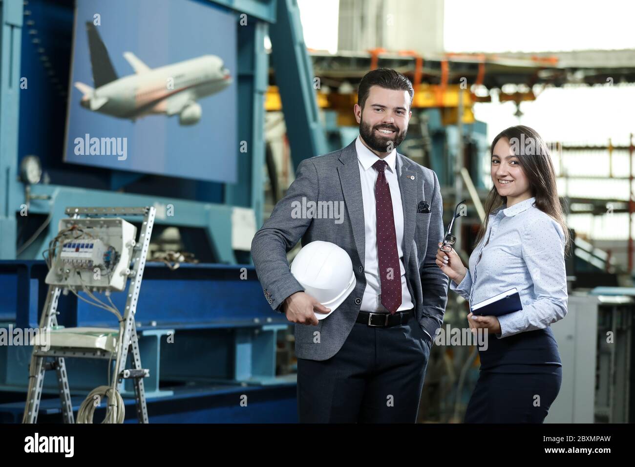 Portrait of a solid businessman with his secretary holding blue ...