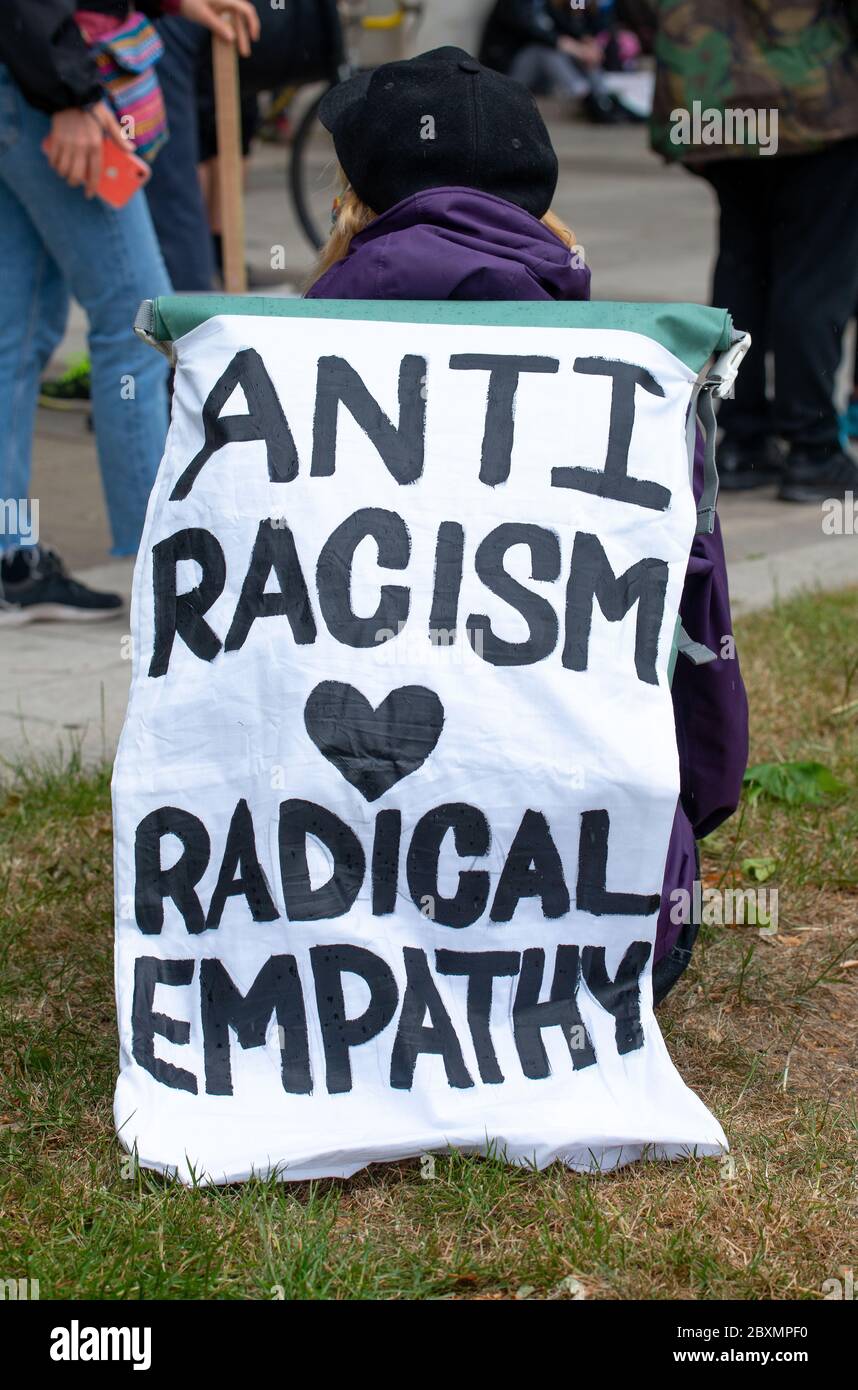 Protester with ANTI RACISM - RADICAL EMPATHY sign attached to back,at ...