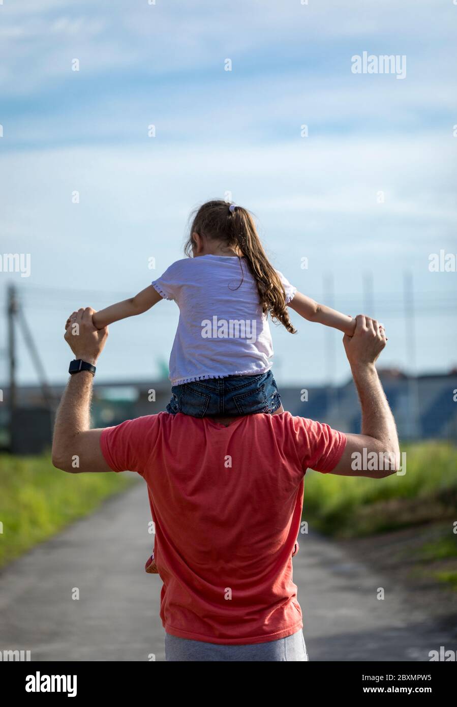 Dad dancing on his shoulders with his daughter in sun. Father travels ...