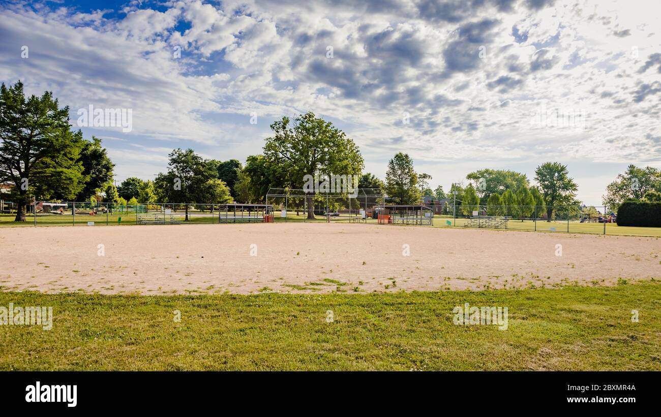 the view from the outfield of a youth baseball field in a city park ...
