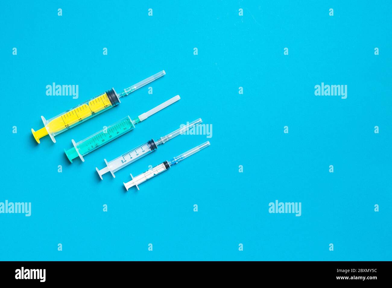 Top view of different syringes at blue background. Medical injection ...