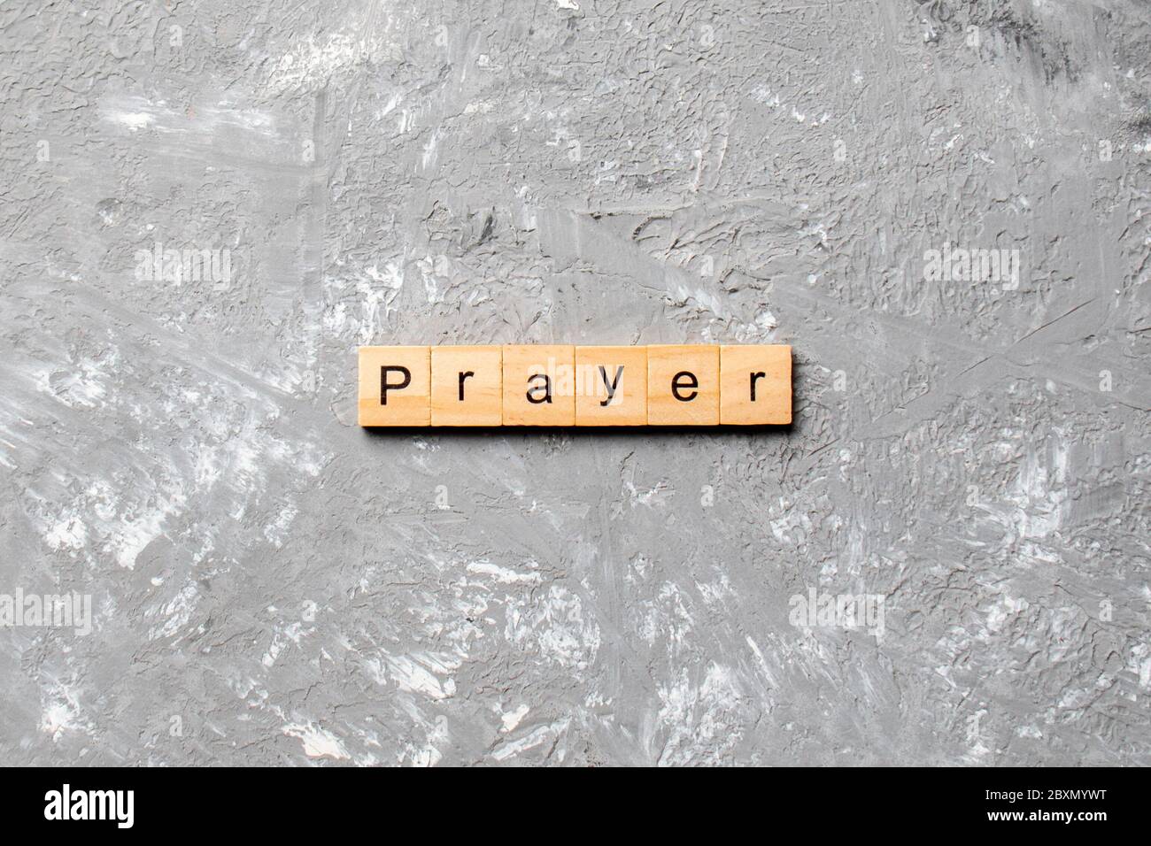 PRAYER word written on wood block. PRAYER text on cement table for your ...