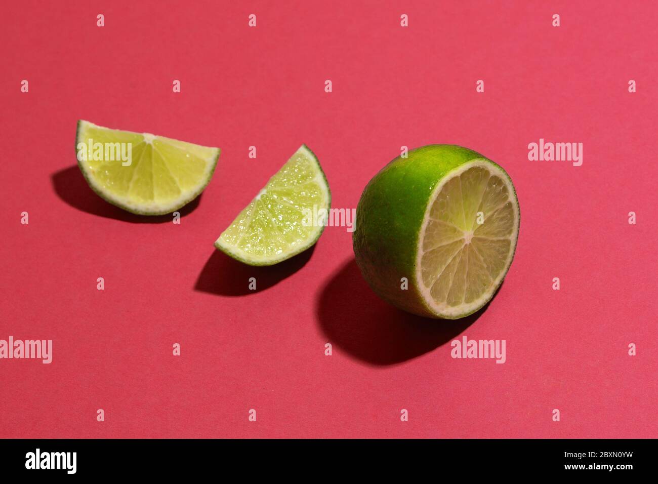 One ripe lime sliced on parts on color surface Stock Photo - Alamy