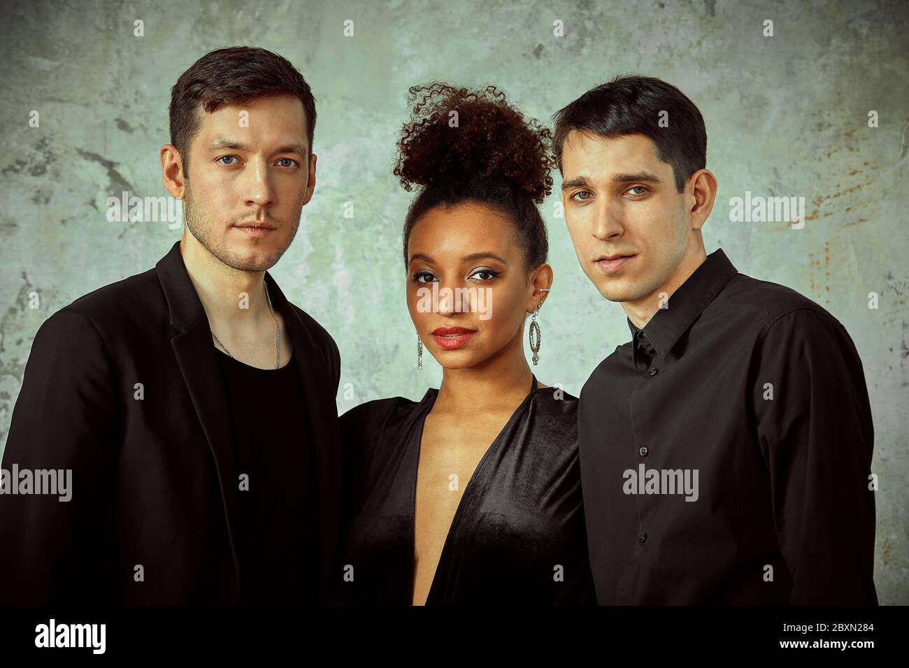 Beautiful fashion models posing on grey background with white box ...