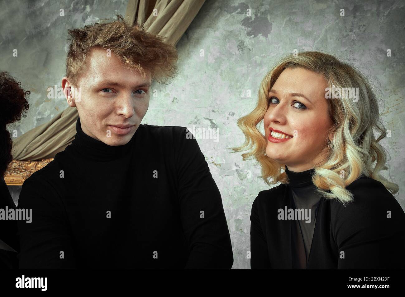 Beautiful fashion models posing on grey background with white box ...