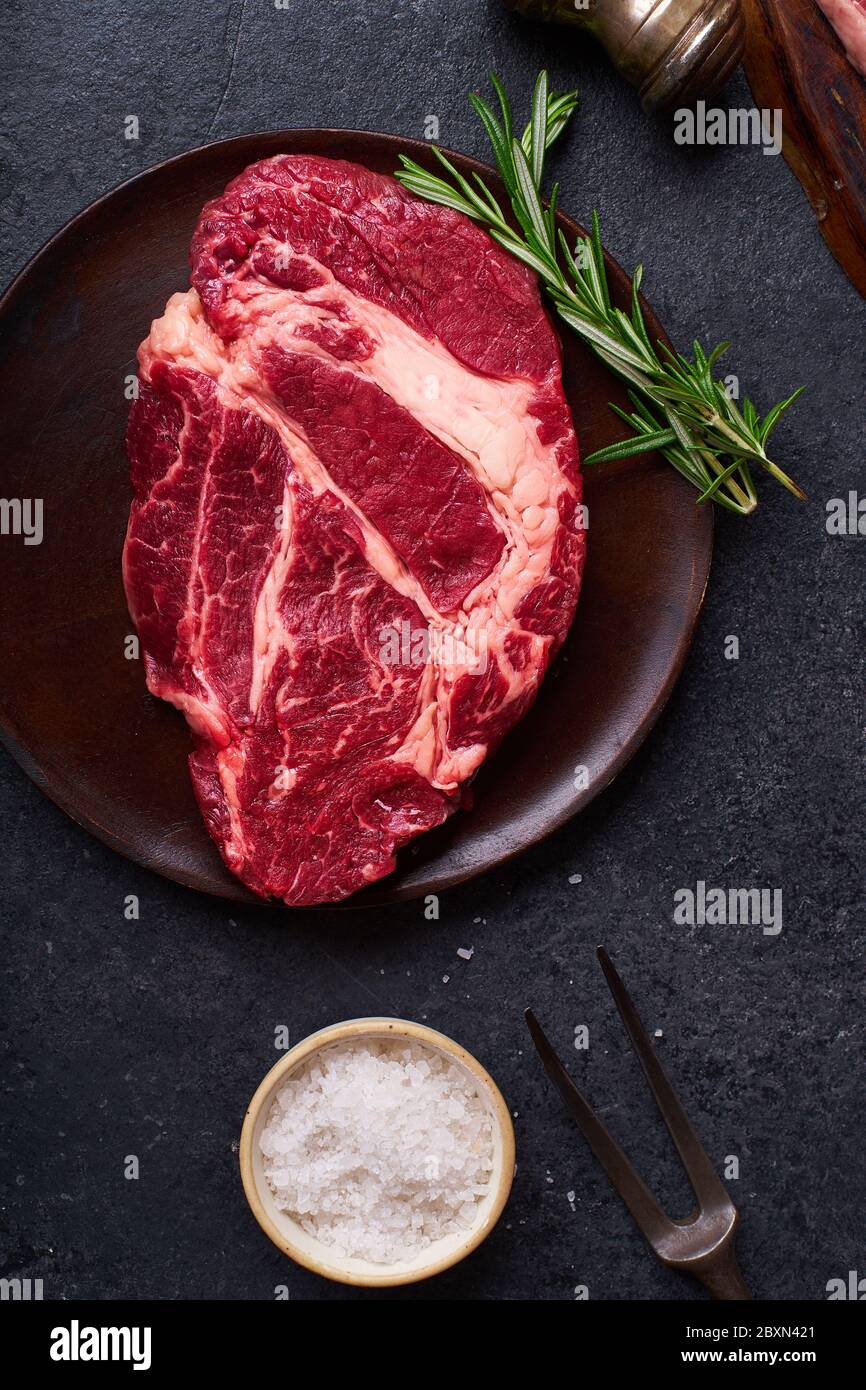 Flat lay Black Angus prime beef chuck roll steak with rosemary and sea ...