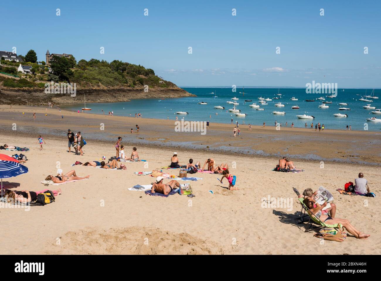 People enjoying summer day on sandy beach, Port Mer, Cancale, Brittany ...