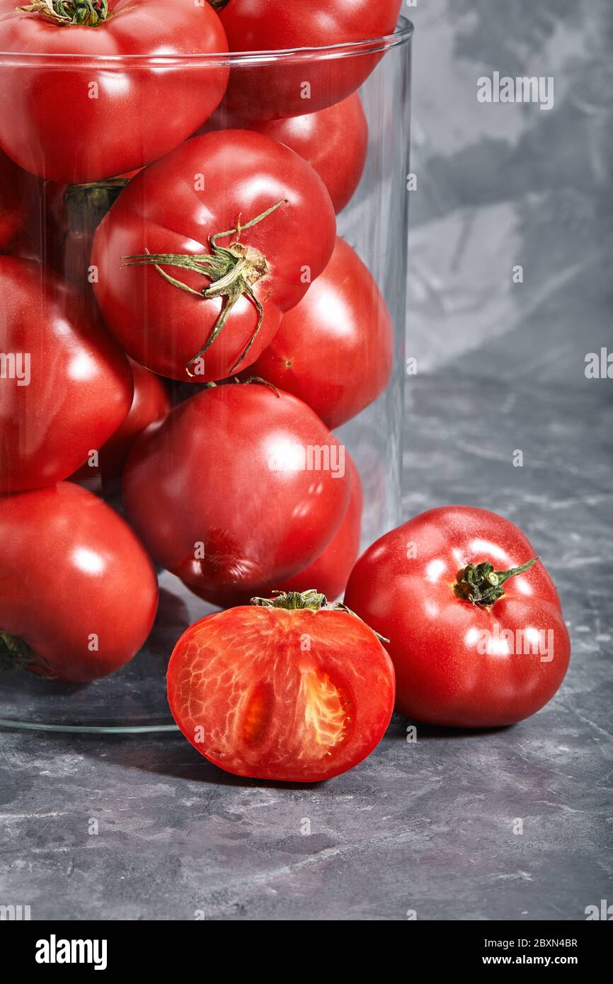 Red tomatoes in a glass vase on a gray background Close-up, tomato ...