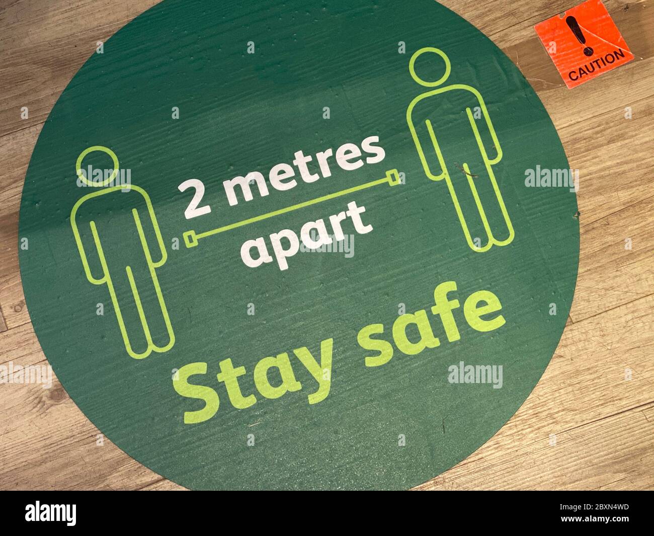 A social distancing sticker on the floor warning people to stay 2 ...