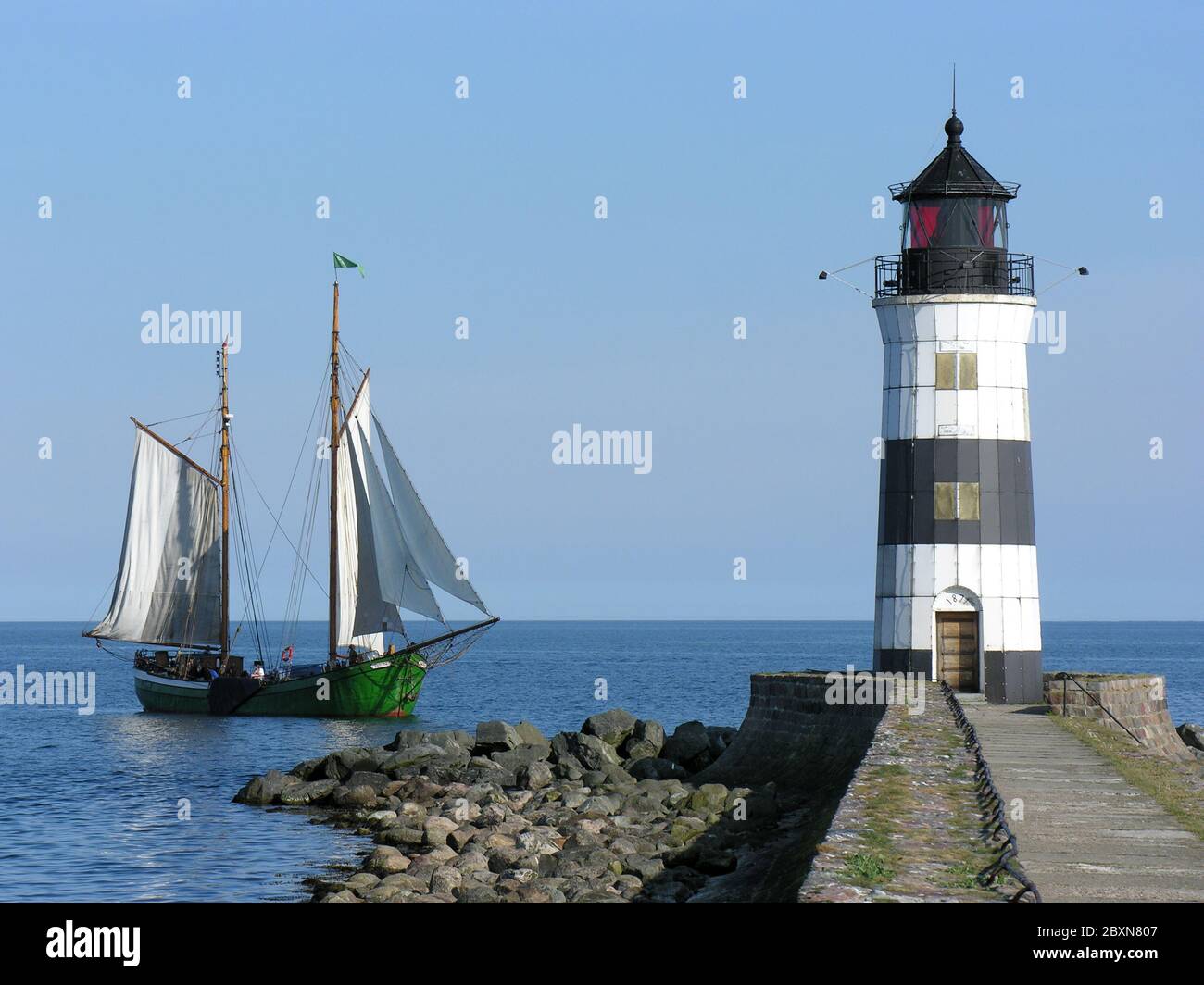 lighthouse and sailboat Stock Photo - Alamy