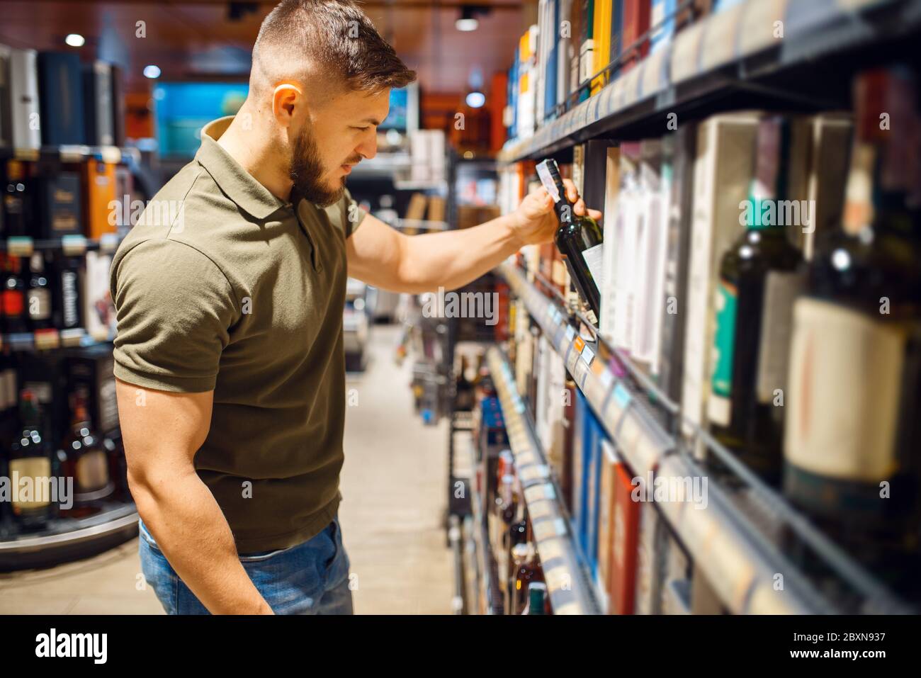 Man choosing alcohol products in grocery store Stock Photo - Alamy