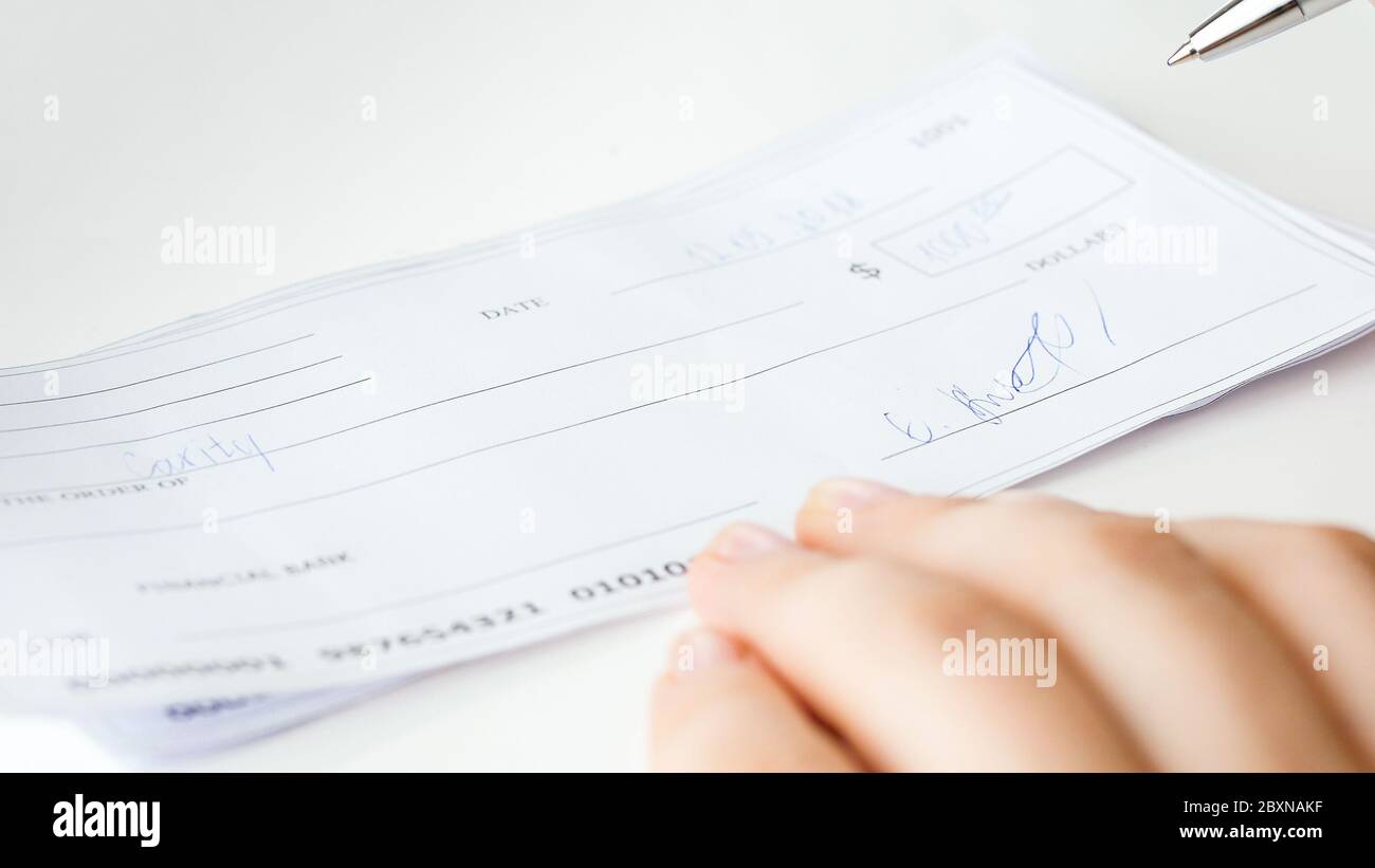 Closeup image of filled and signed banking cheque Stock Photo - Alamy