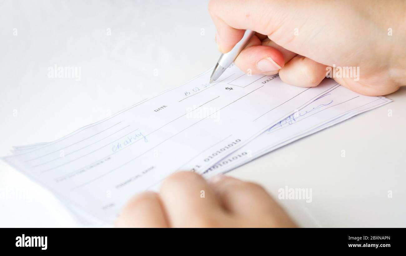 Man filling banking cheques for monthly payments and taxes Stock Photo ...