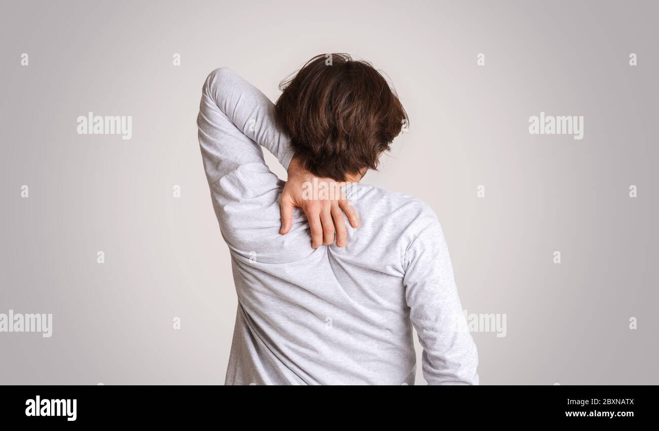 Itching and allergies. Guy scratches his back with hand isolated on ...