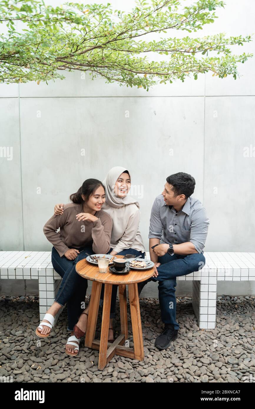 three friends chatting and enjoying coffee together in the coffee shop ...