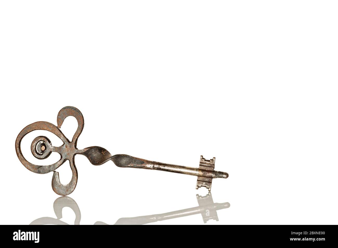 Single old metal key on white background with reflection, isolated on ...