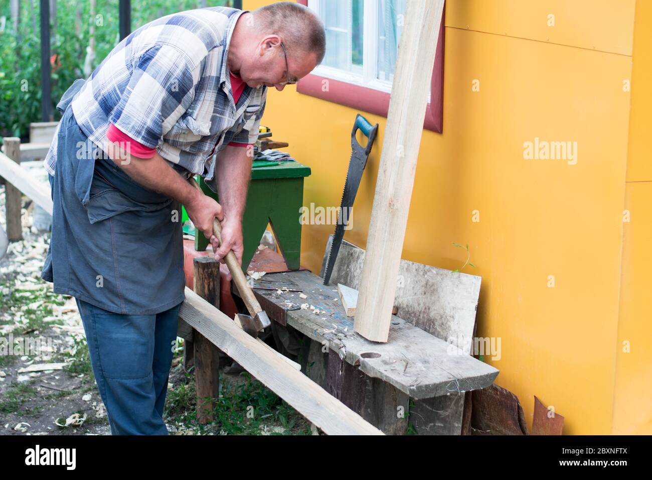 Man hacking a wooden board with an ax Stock Photo - Alamy