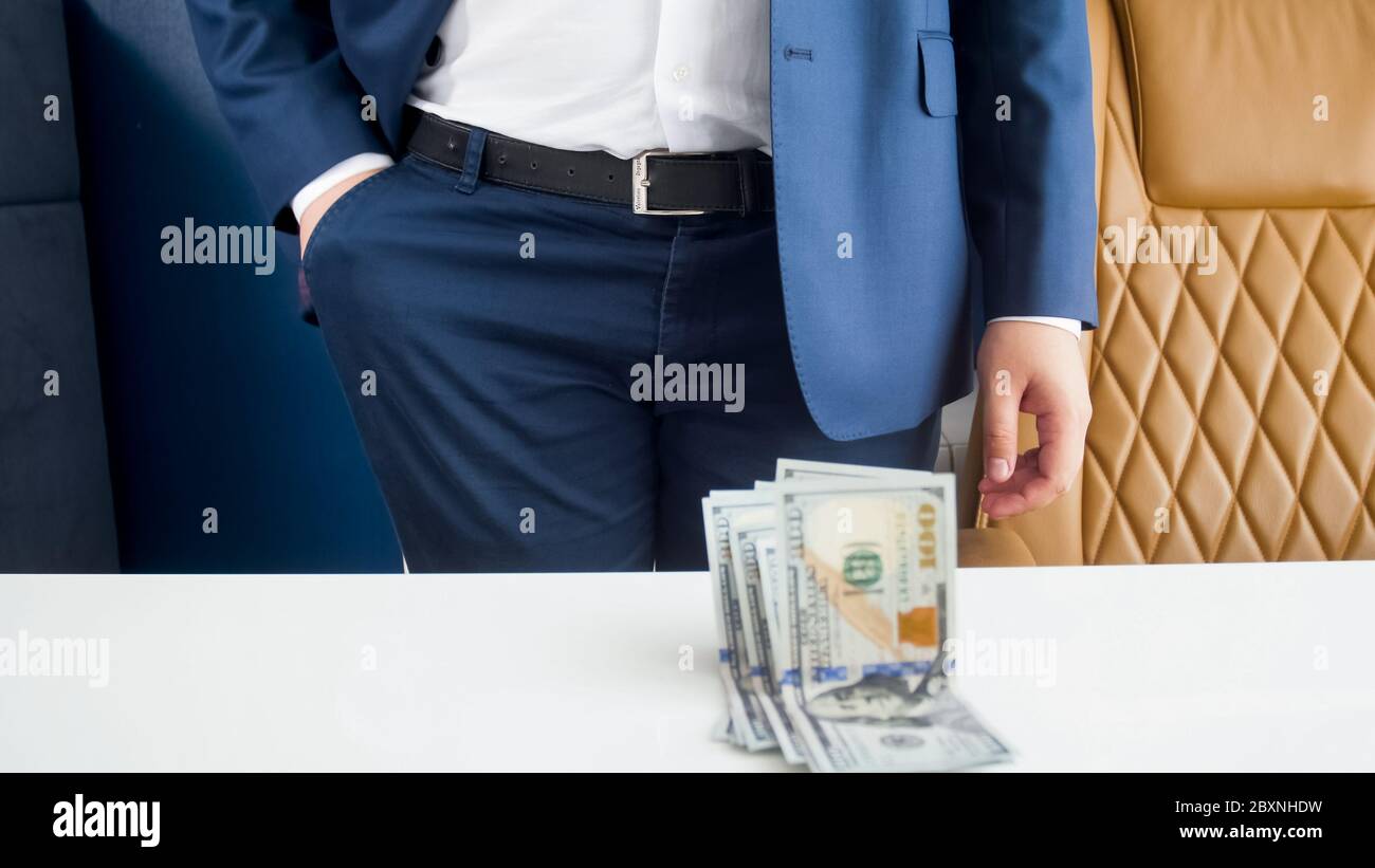 Stylish wealthy businessman in blue suit looking on wad of money Stock ...